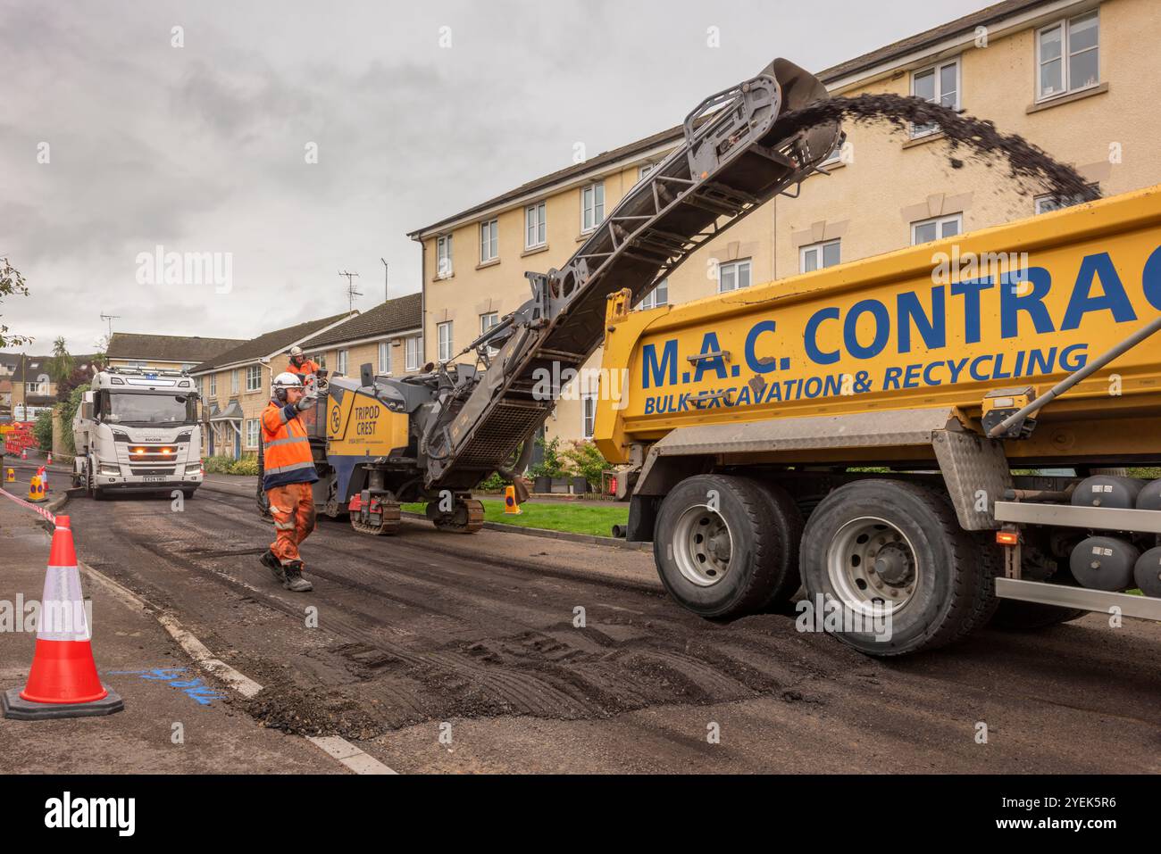 A team of workman operating heavy machinery to resurface a residential ...