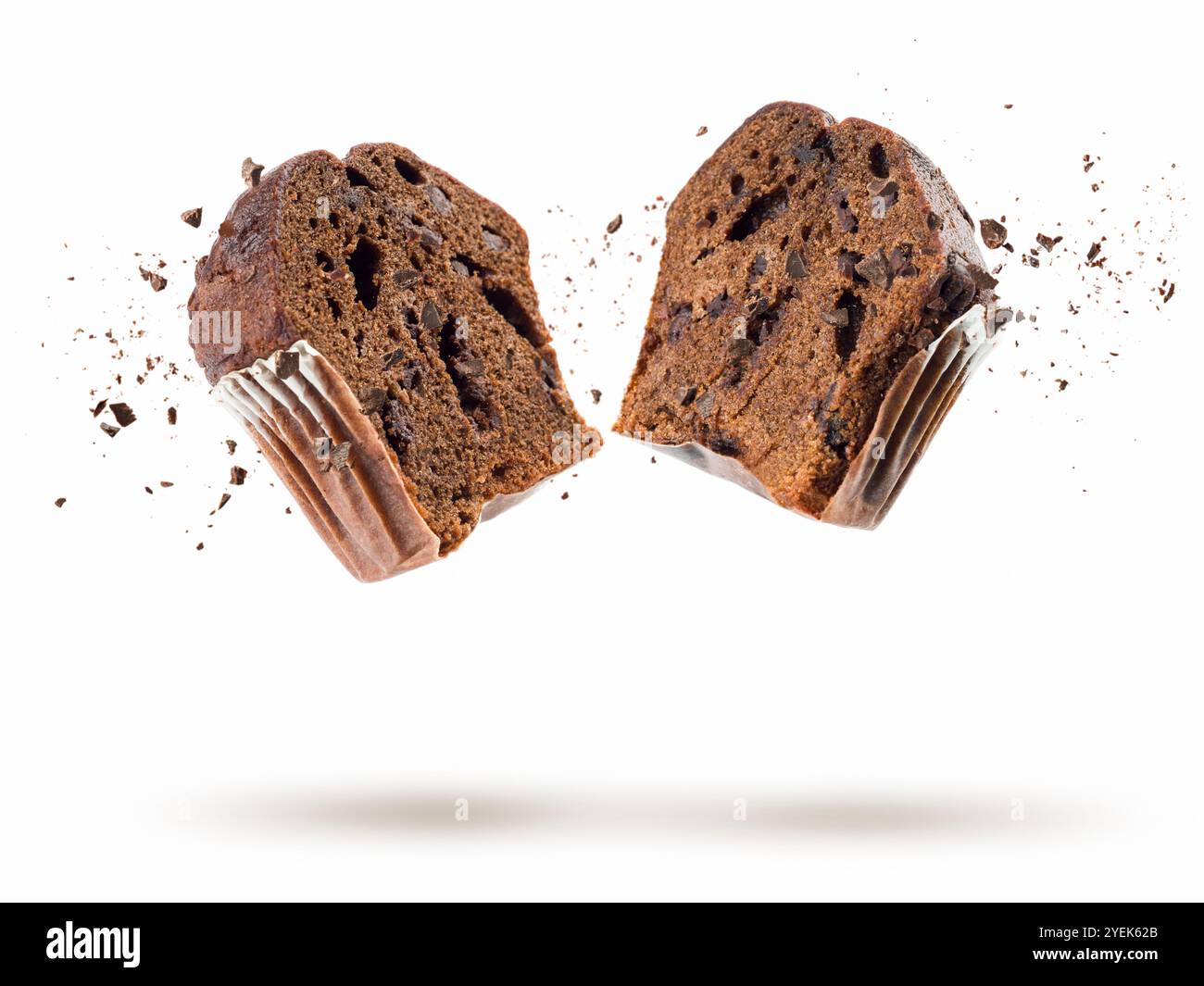 Chocolate chip muffin cut in half flying with chocolate chips on white ...