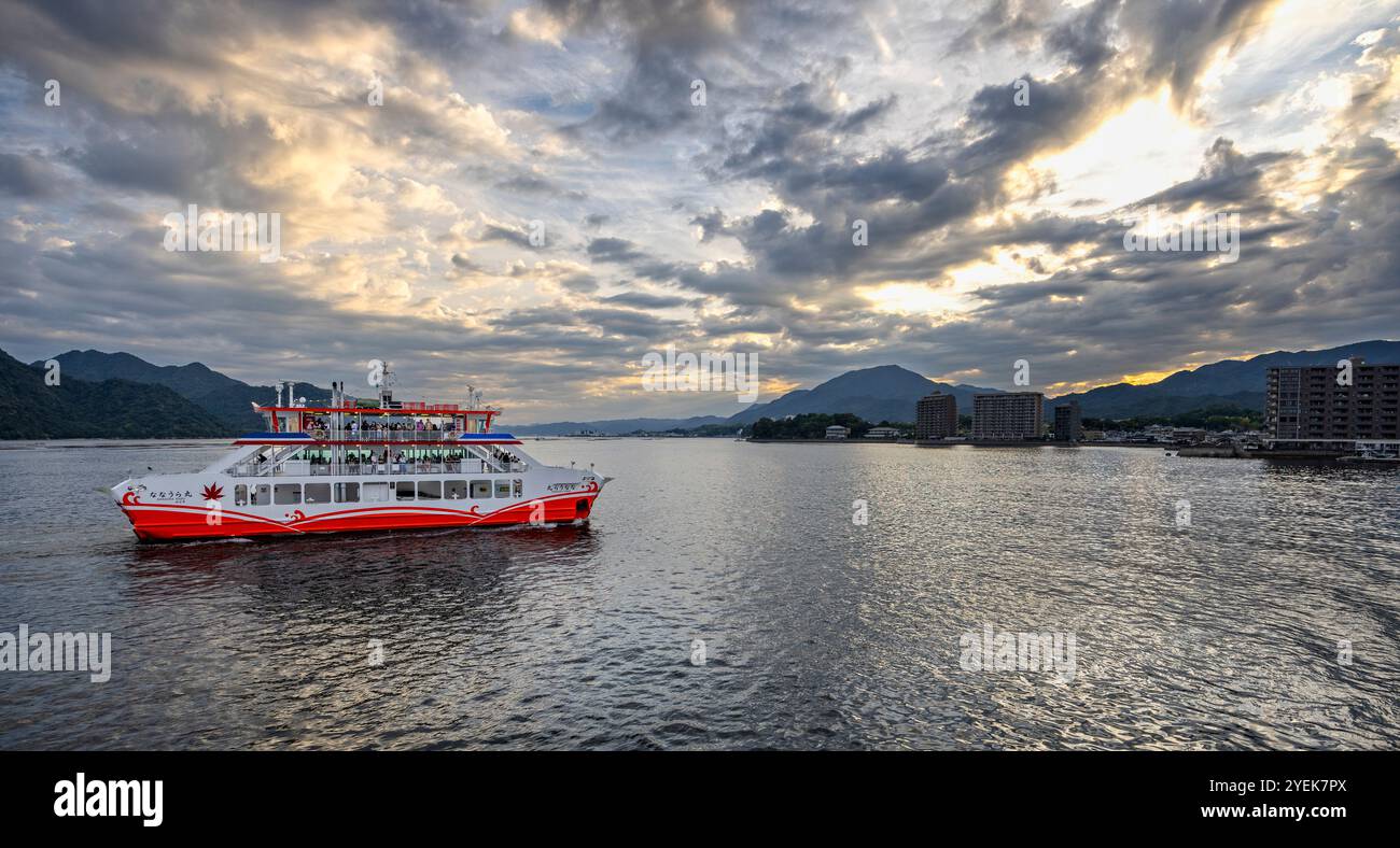 Ferry en route from Miyajimaguchi to Miyajima Island with sunset sky ...