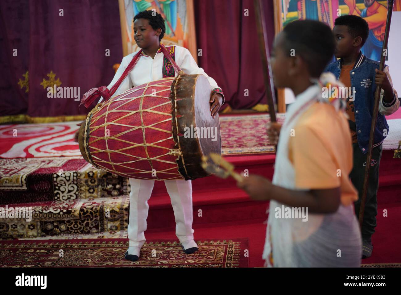 A young member of the Ethiopian Orthodox Tewahedo Church holds the ...