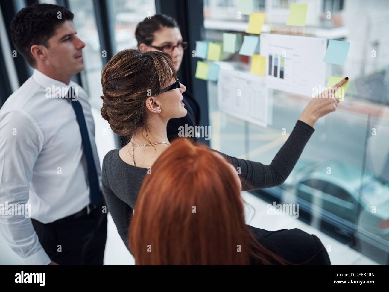 Employees, sticky notes and ideas on glass in office, brainstorming and ...