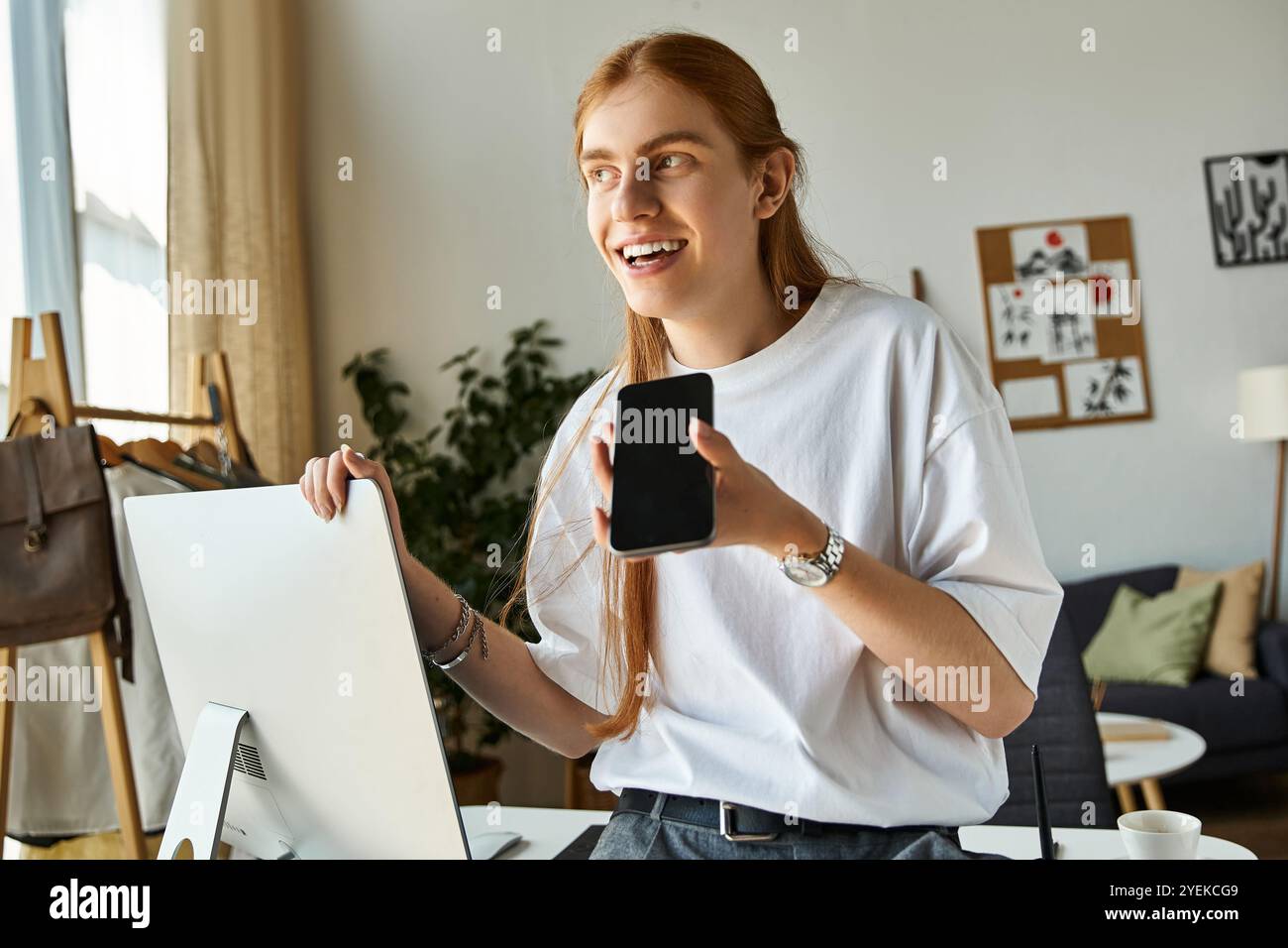 A cheerful young man talks on his smartphone while smiling at his ...