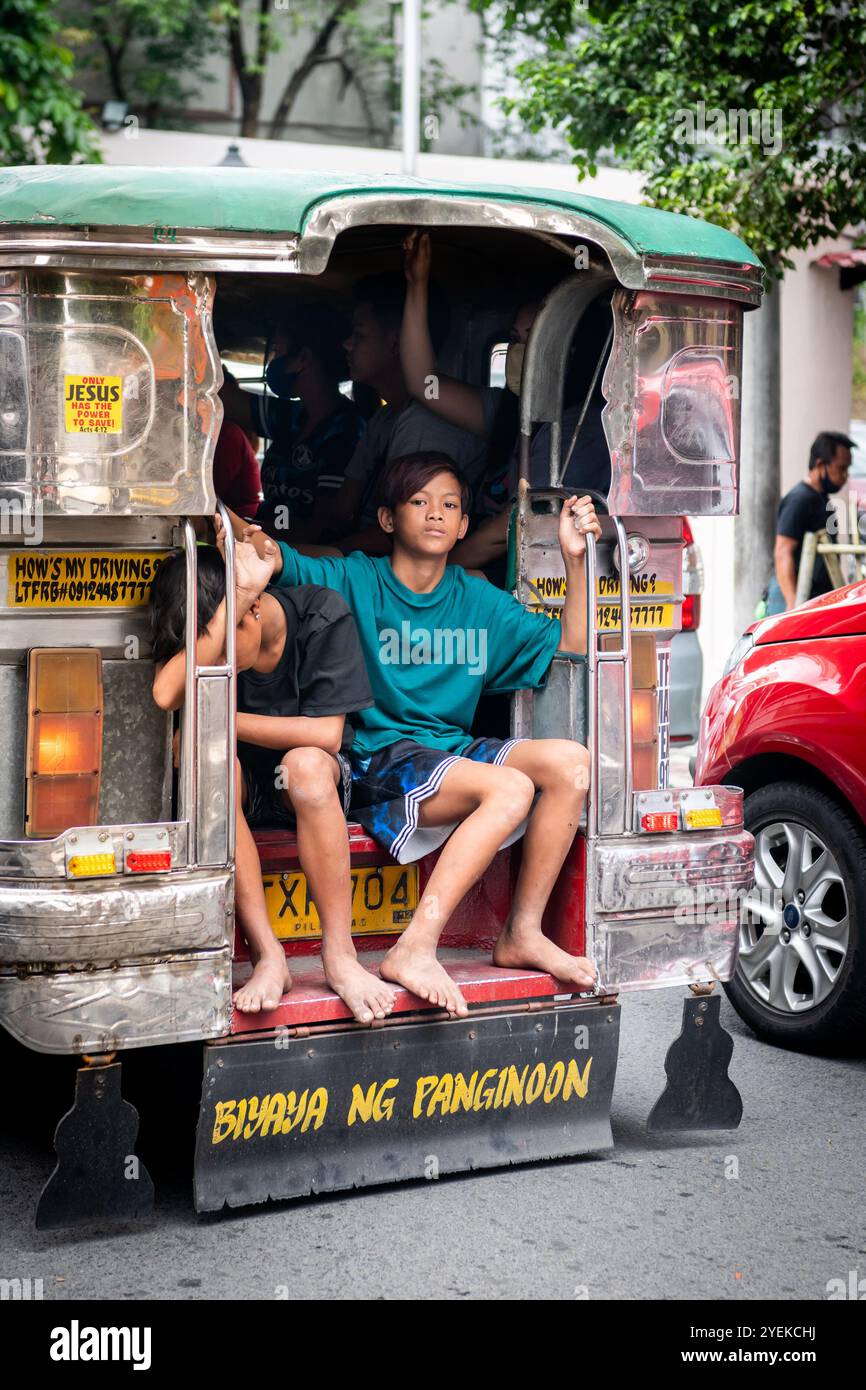 Young filipino boys sit at the back of a Jeepney in Manila, The ...