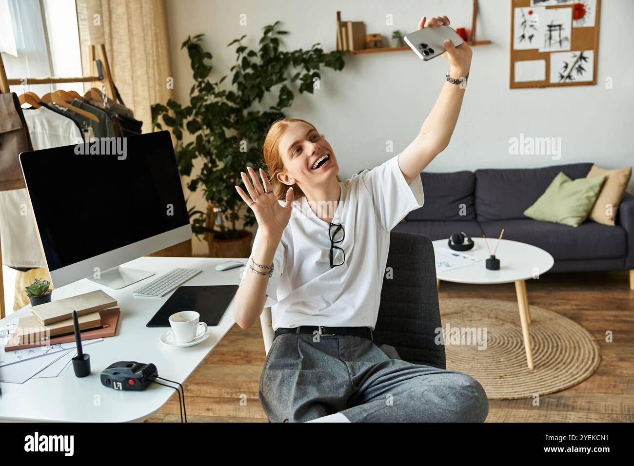 A young man happily waves and poses for a selfie in a contemporary ...