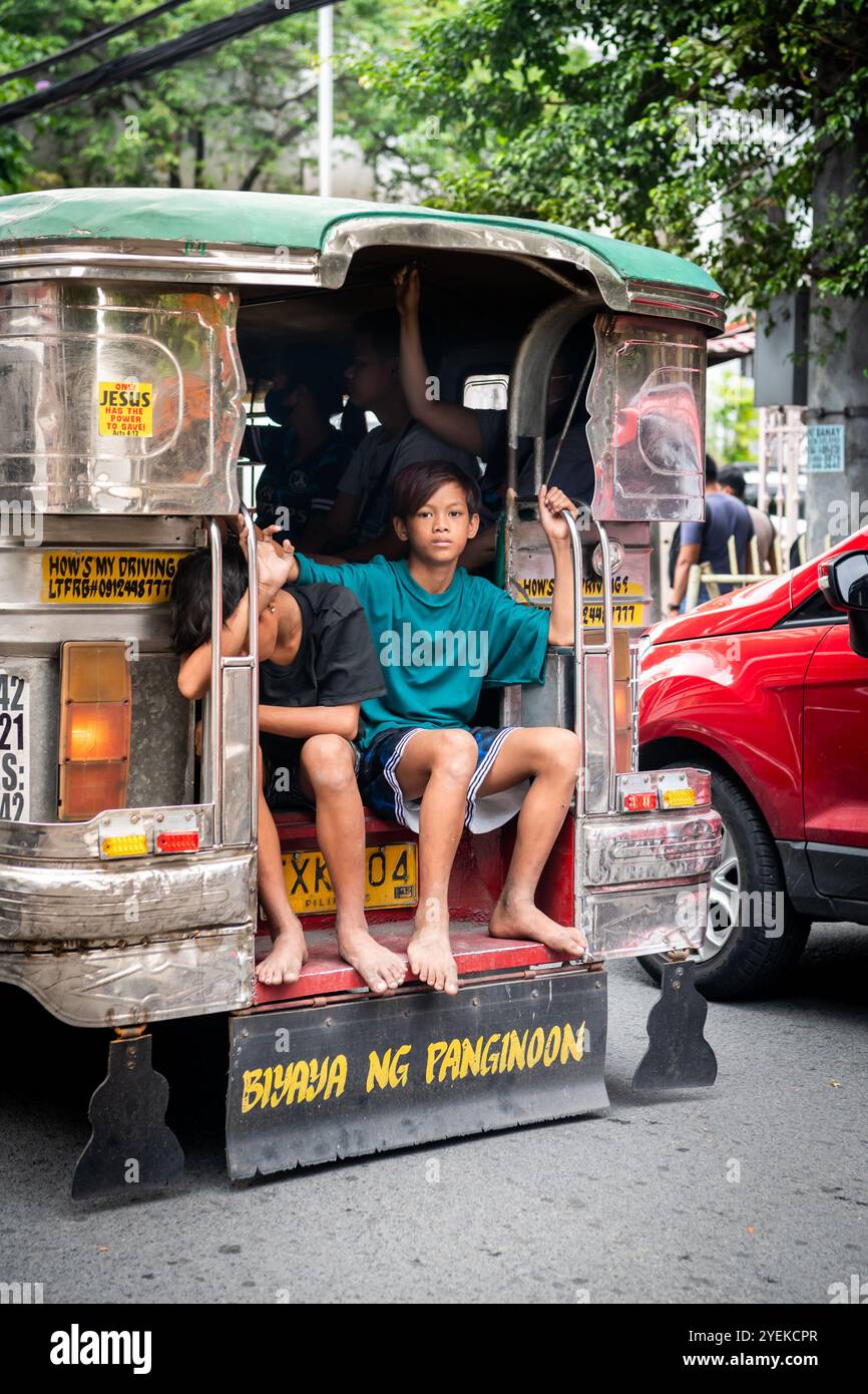 Young filipino boys sit at the back of a Jeepney in Manila, The ...