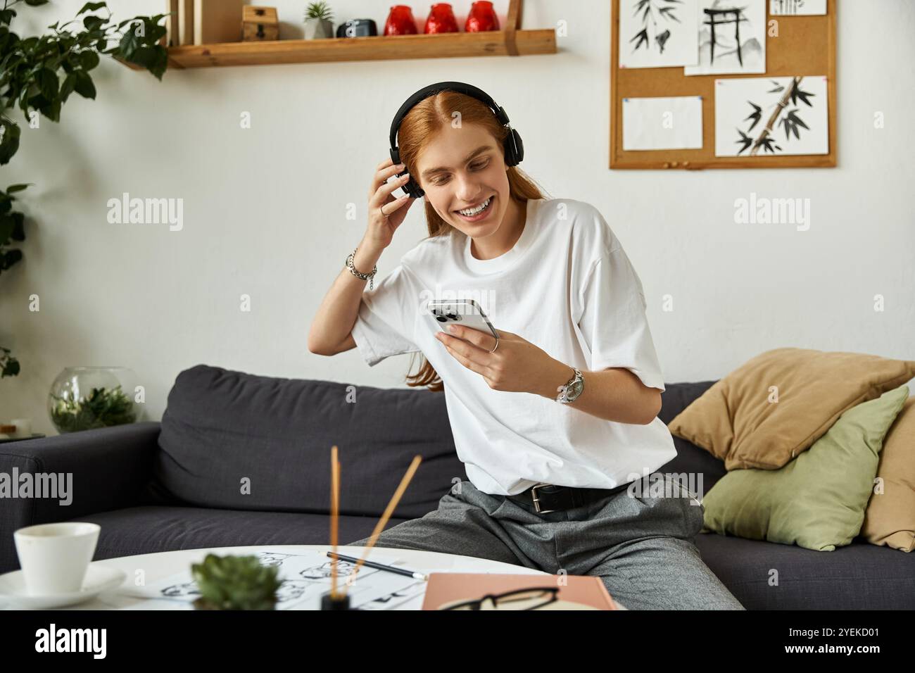 A young man smiles joyfully, listening to music on headphones in a ...