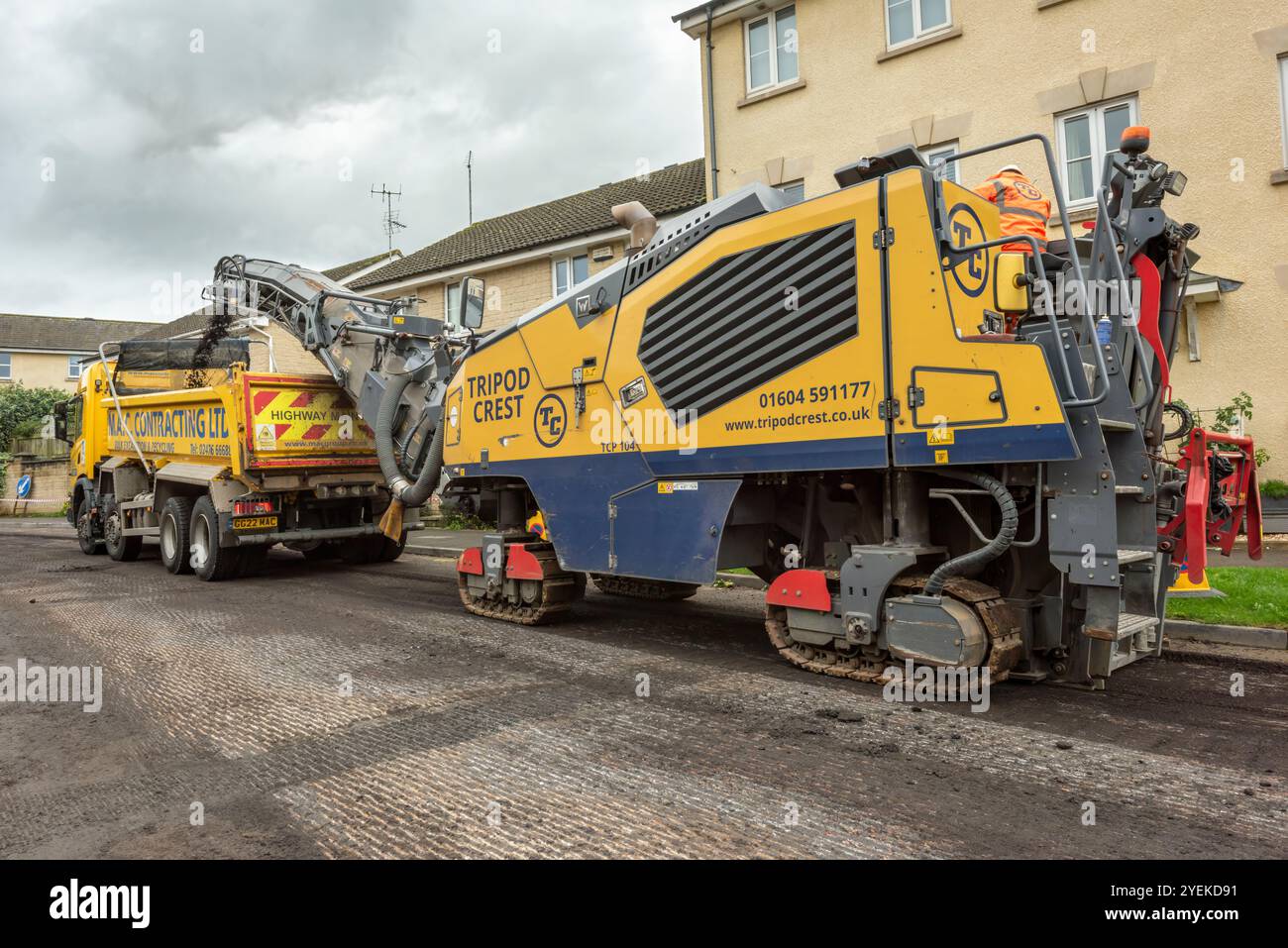 A team of workman operating heavy machinery to resurface a residential ...