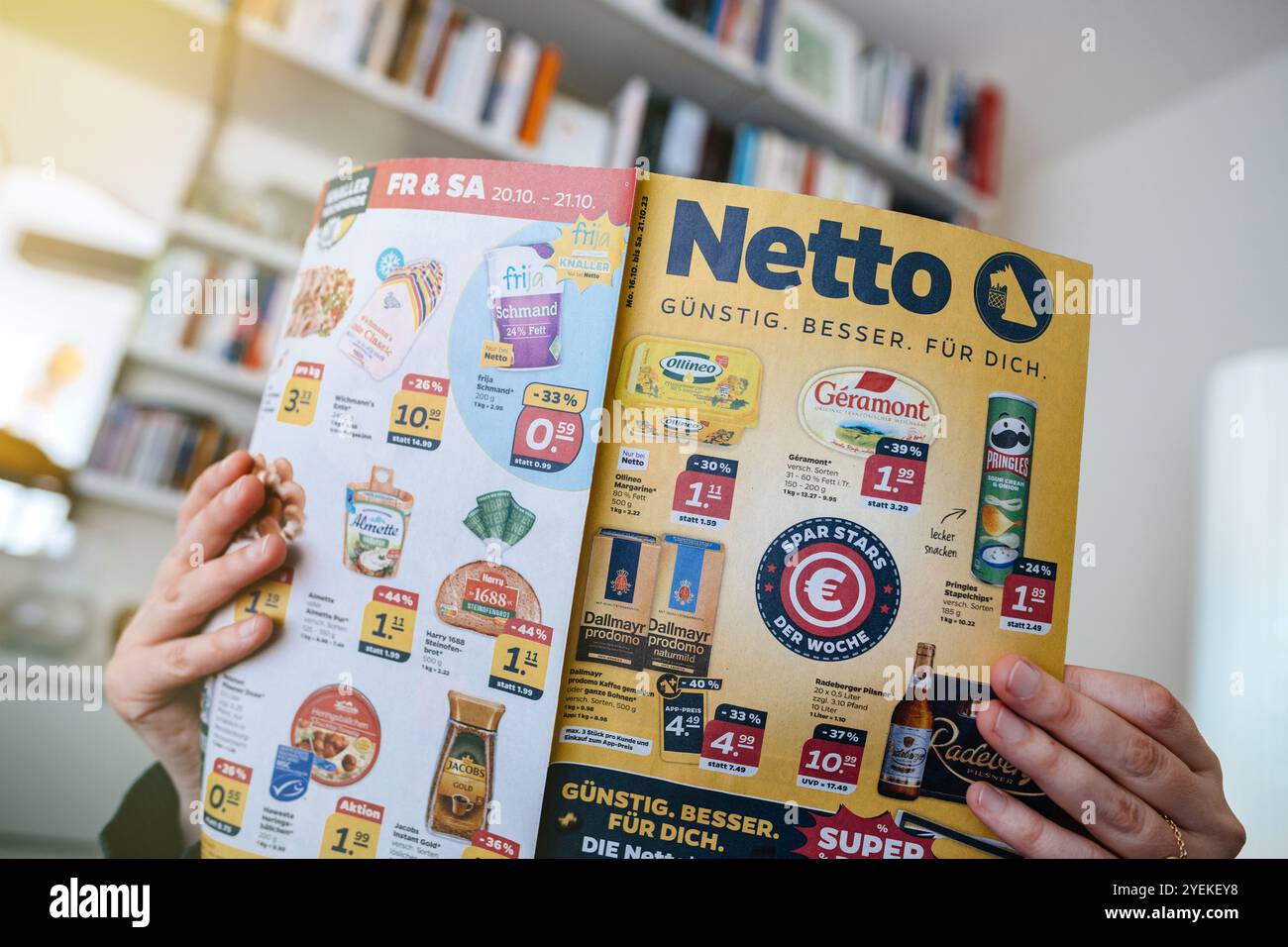 Frankfurt, Germany - Nov 3, 2024: Person reading a Netto supermarket ...