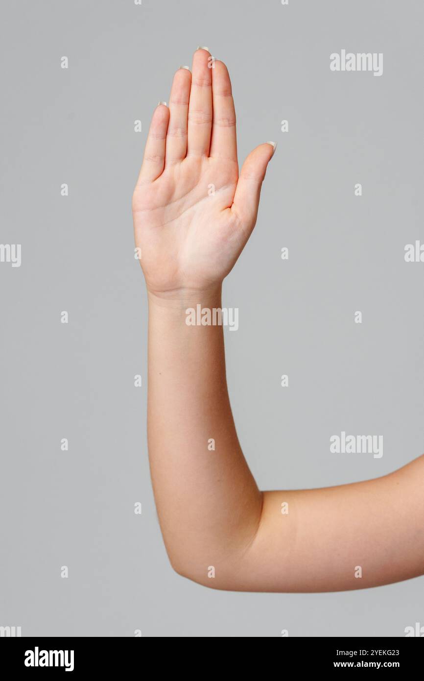 Raised hand against a neutral background in a softly lit setting Stock ...
