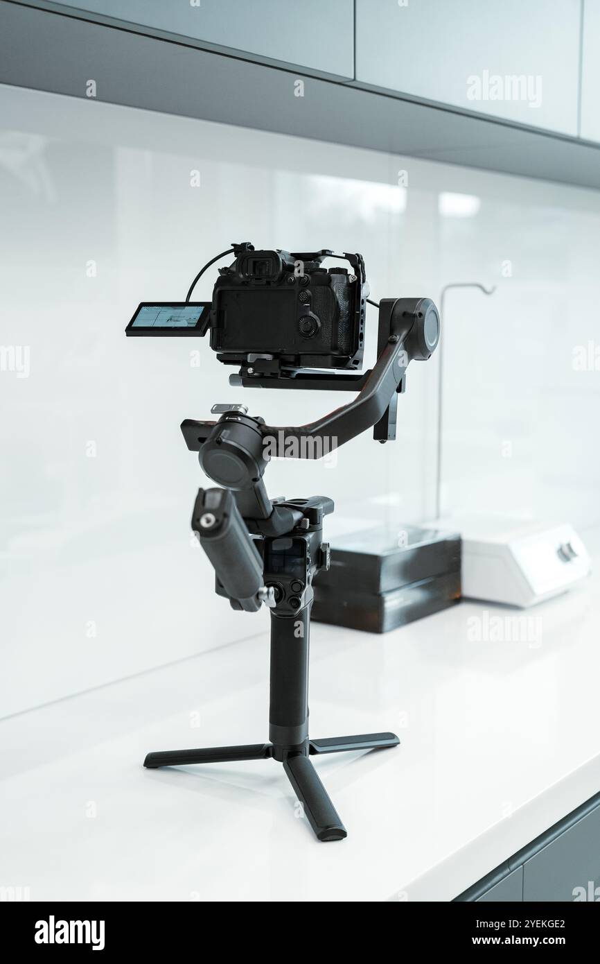 A camera gimbal stabilizer placed on a white countertop in a modern ...