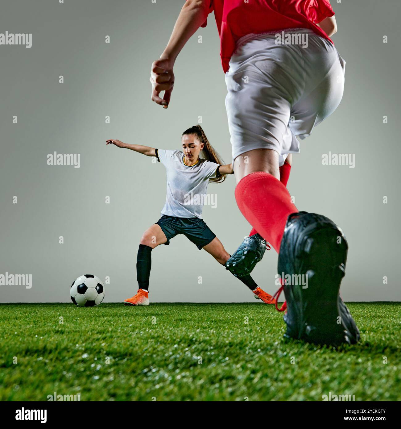 Two female soccer players focused on gaining possession of ball. Women ...
