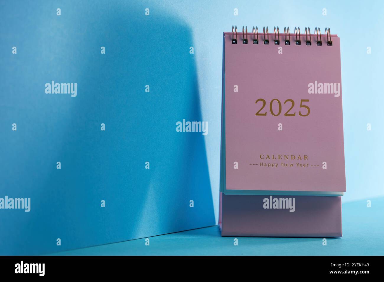 pink color 2025 desk calendar against blue color background Stock Photo ...