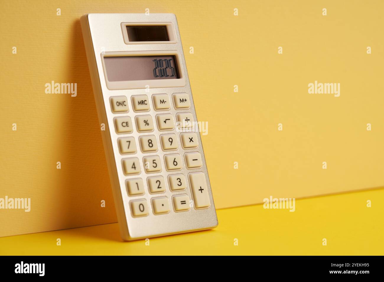 white calculator with number 2025 on screen lean on yellow wall Stock ...
