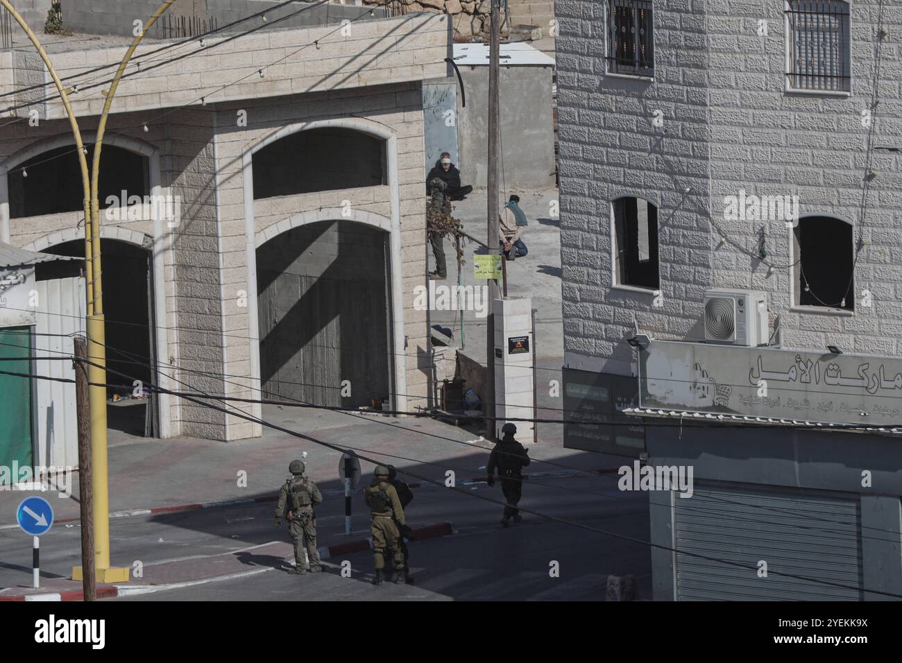 Israeli soldiers move blindfolded Palestinian detainees during a military raid in Dura, south of ...