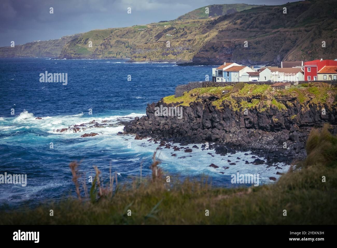 Bright houses on the cliff at Atlantic ocean coast in Azores islands ...