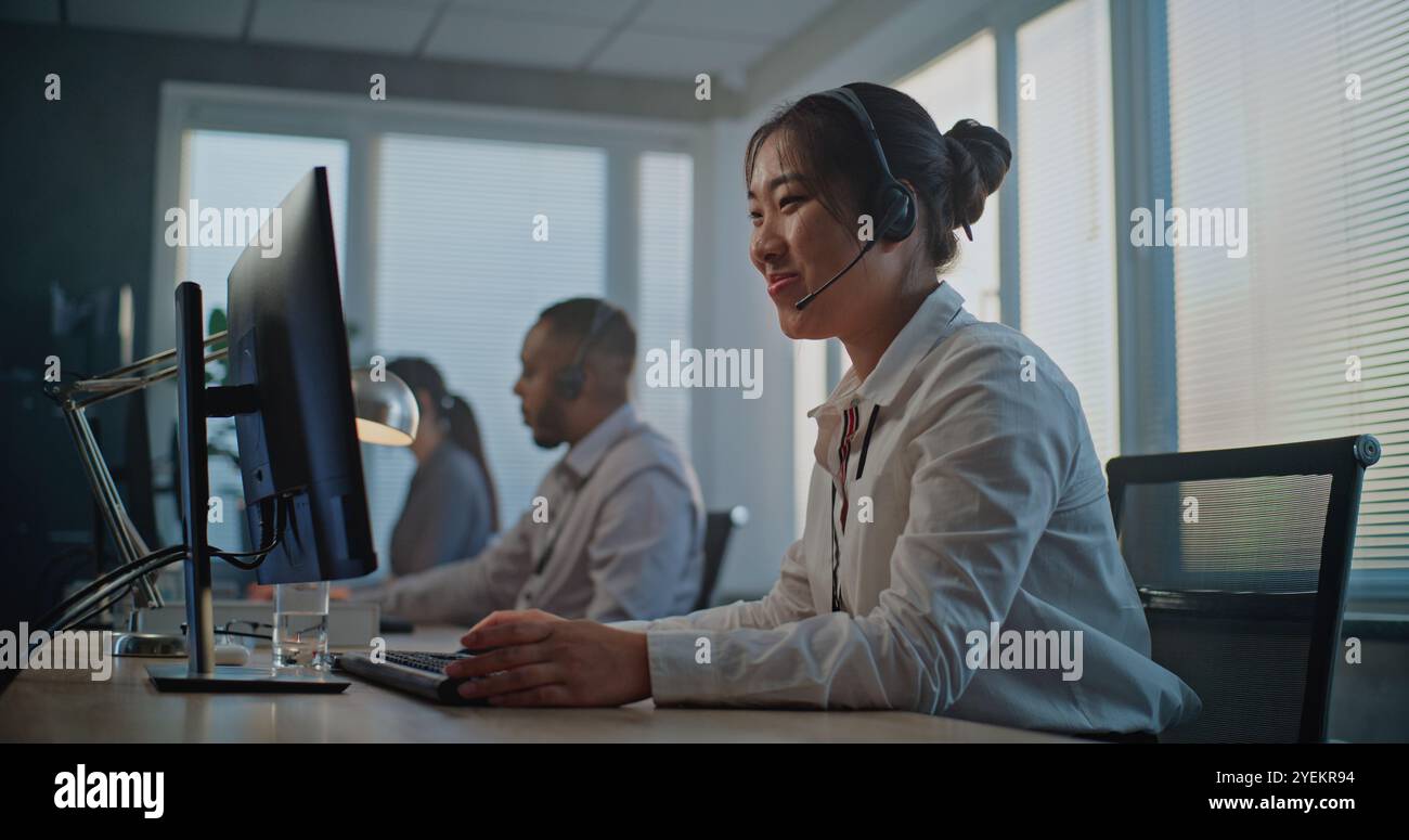 Call center office: Dolly shot of tired, stressed Asian hotline ...