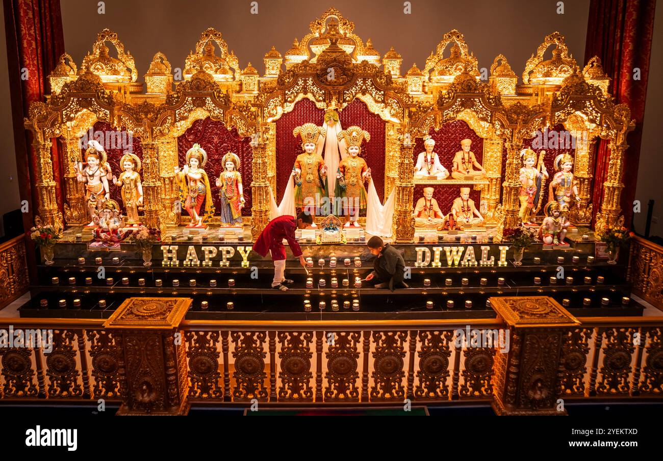 Left to right Arjun Patel and Jay Patel light candles during ...