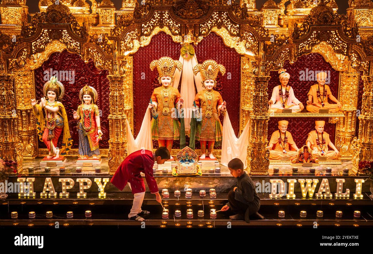 Left to right Arjun Patel and Jay Patel light candles during ...