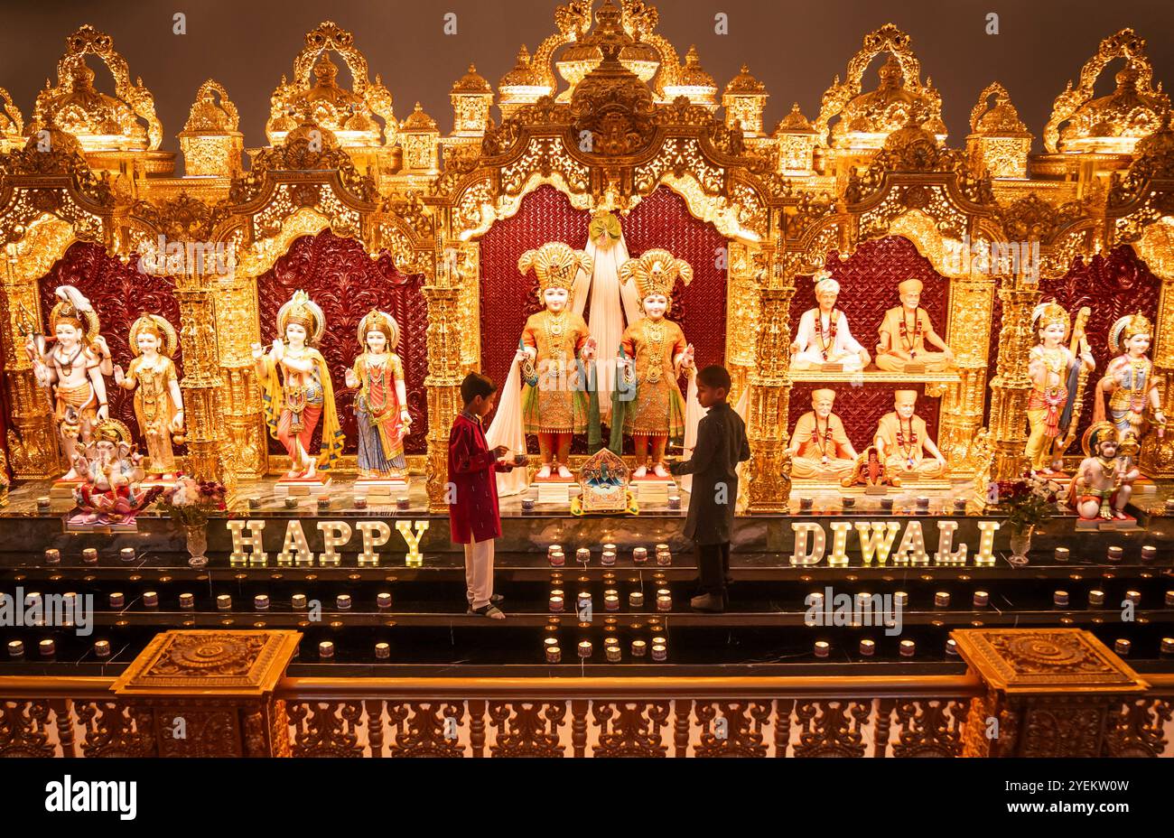 Left to right Arjun Patel and Jay Patel light candles during ...