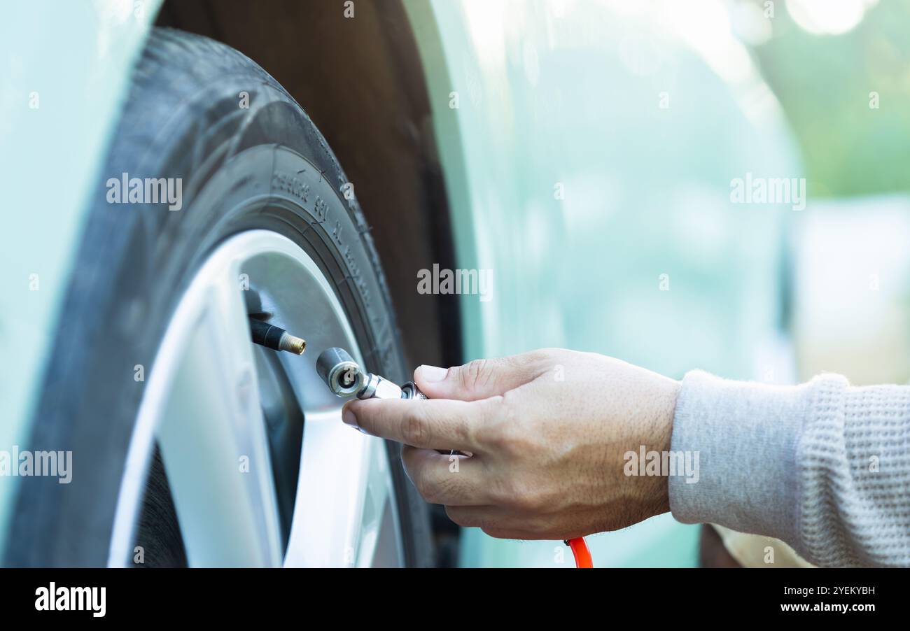 A car owner inflates a tire, highlighting the importance of tire ...