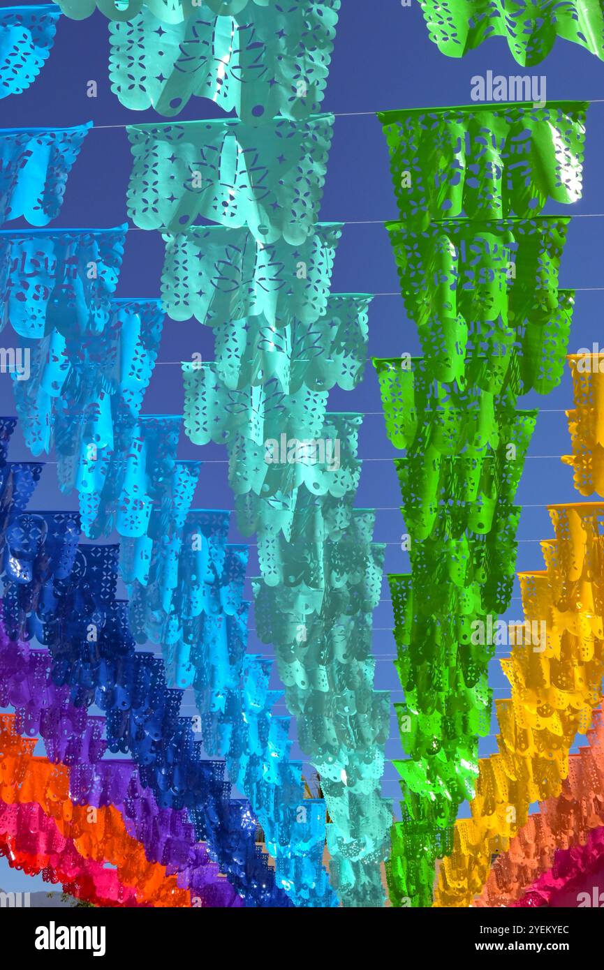 Rows of rainbow coloured flags hanging from wires above a street Stock ...
