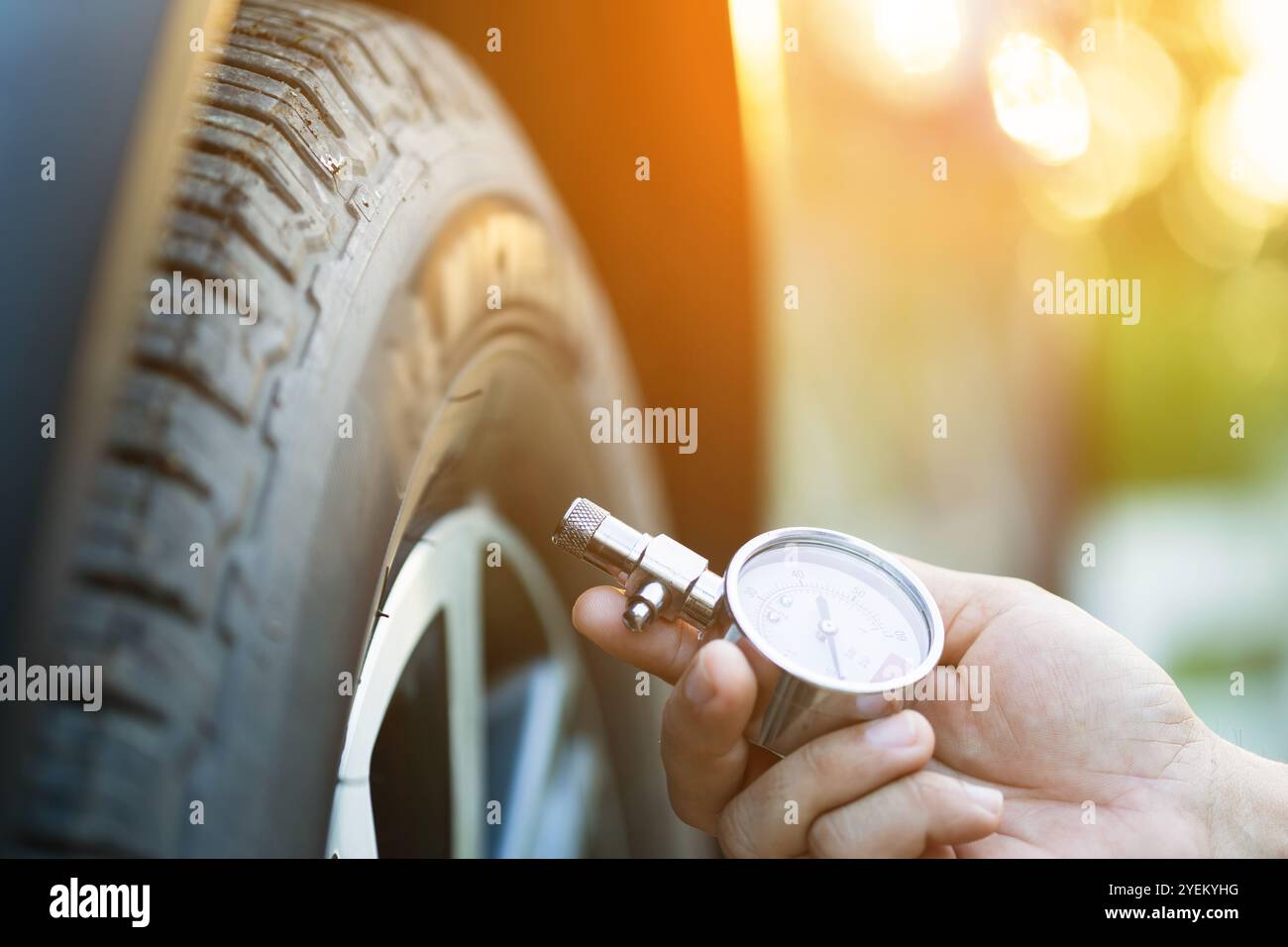 A car owner uses a pressure gauge to check tire inflation, emphasizing vehicle readiness and the ...