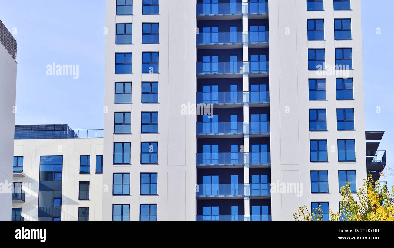 Modern high-rise apartment building in white, stand tall against a blue ...