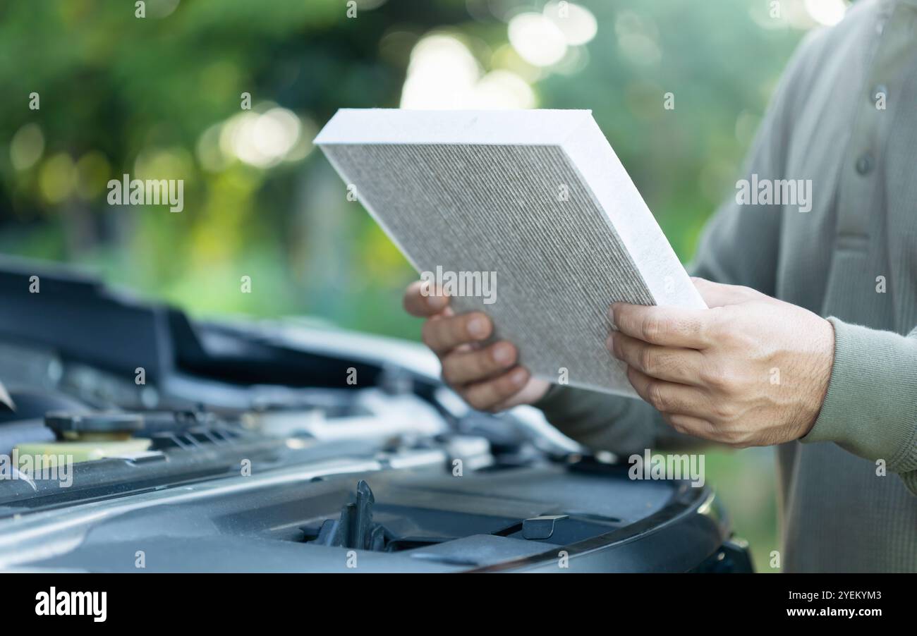 A car owner holds an air filter for examination. Importance of regular ...
