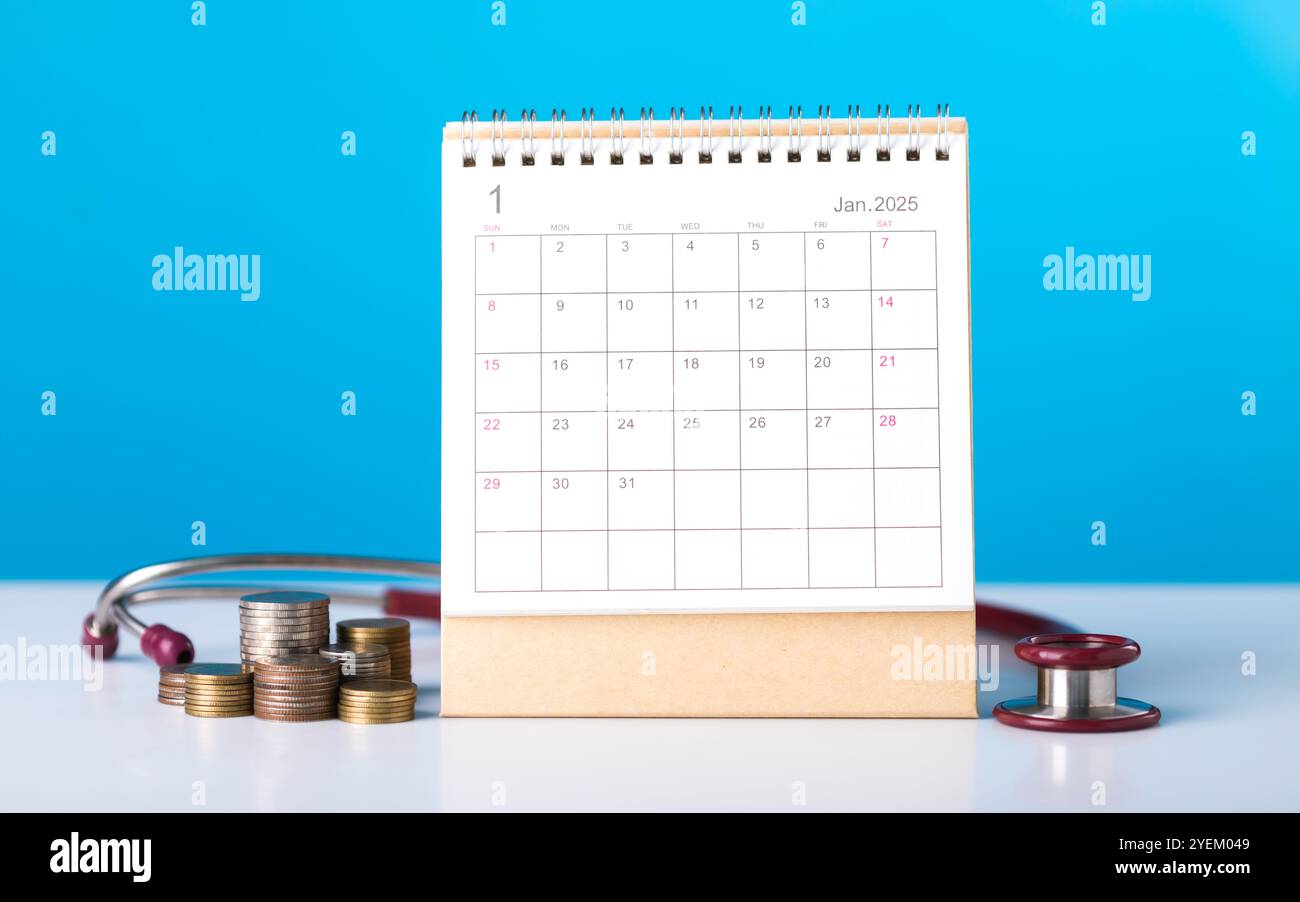 A desk calendar, a stack of coins, and a stethoscope placed together on ...