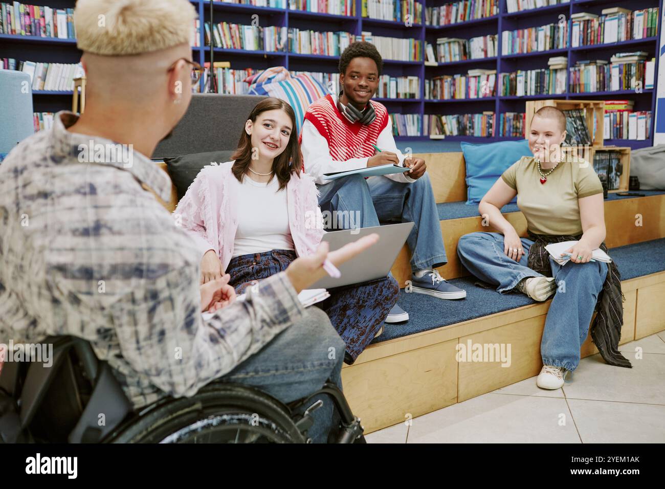 Group of diverse students seated on library steps engaging in ...
