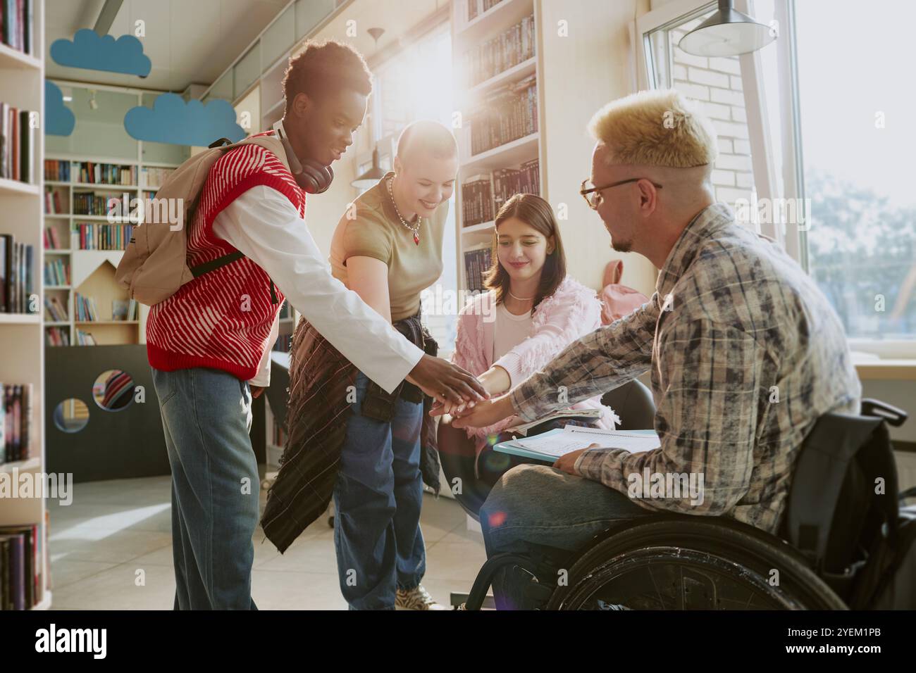 Group of students collaborating in school library with sunlight ...