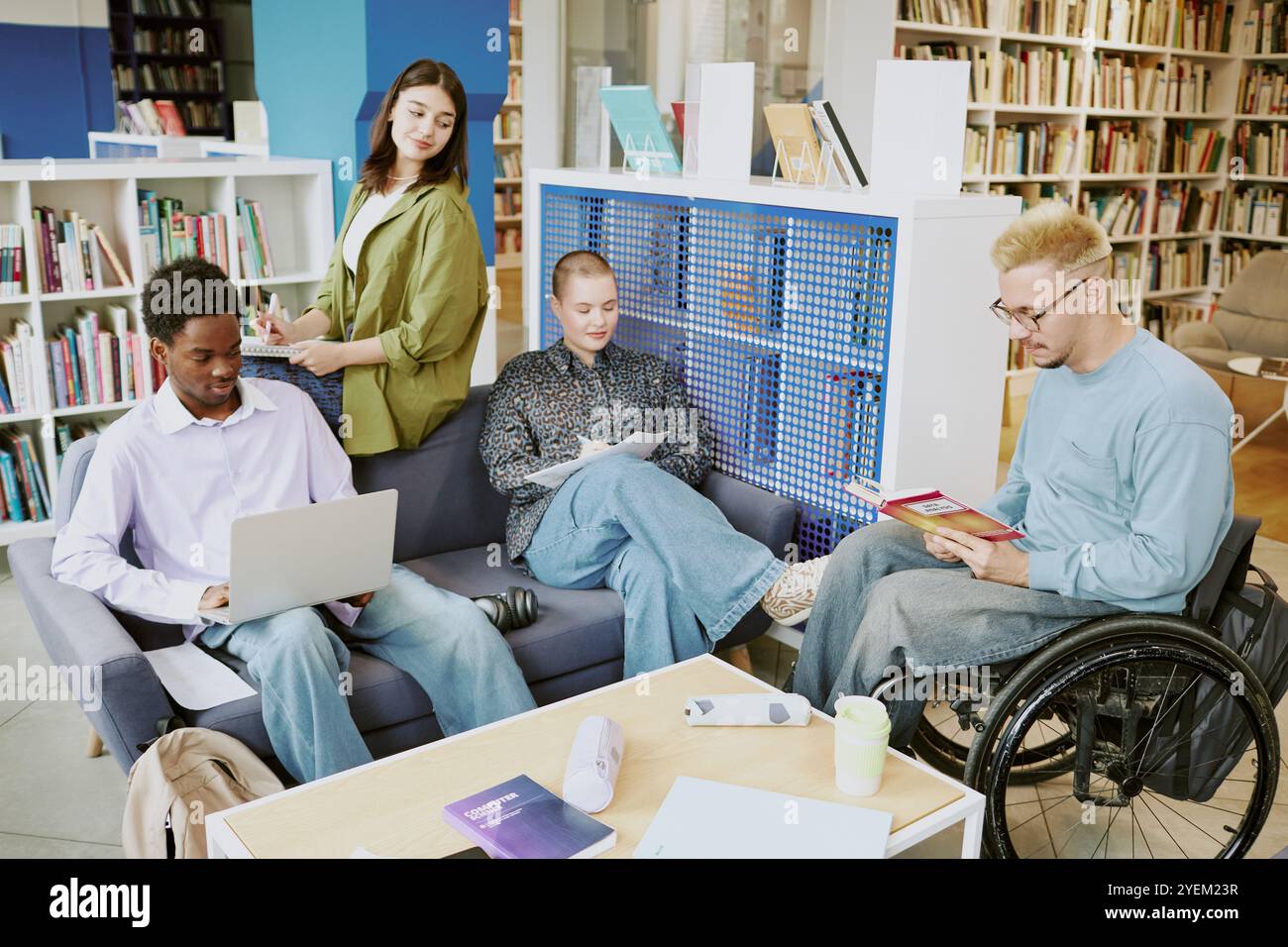 Group of students engaging in study and discussion in library setting. Multiracial group ...