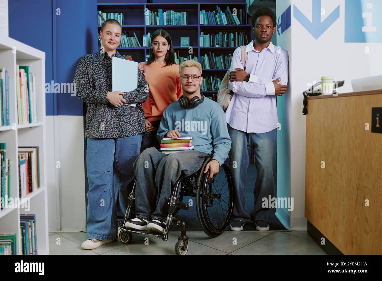 Group of diverse students standing in library with bookshelves ...