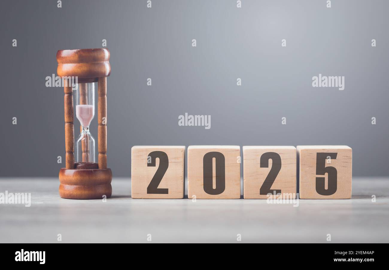 Wooden block displaying '2025' sits beside an hourglass, symbolizing ... Wooden block displaying '2025' sits beside an hourglass, symbolizing ...