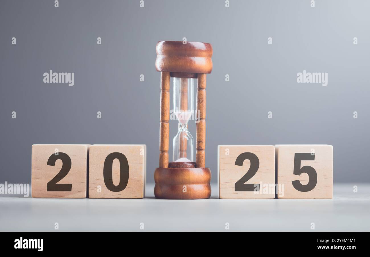 Wooden block displaying '2025' sits beside an hourglass, symbolizing ...
