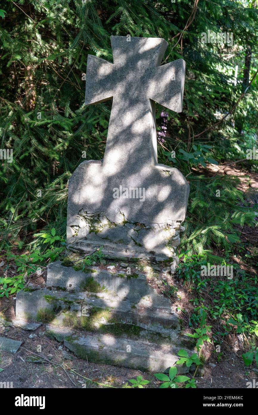 Cross monument on graves of an abandoned old cemetery. Graveyard in ...