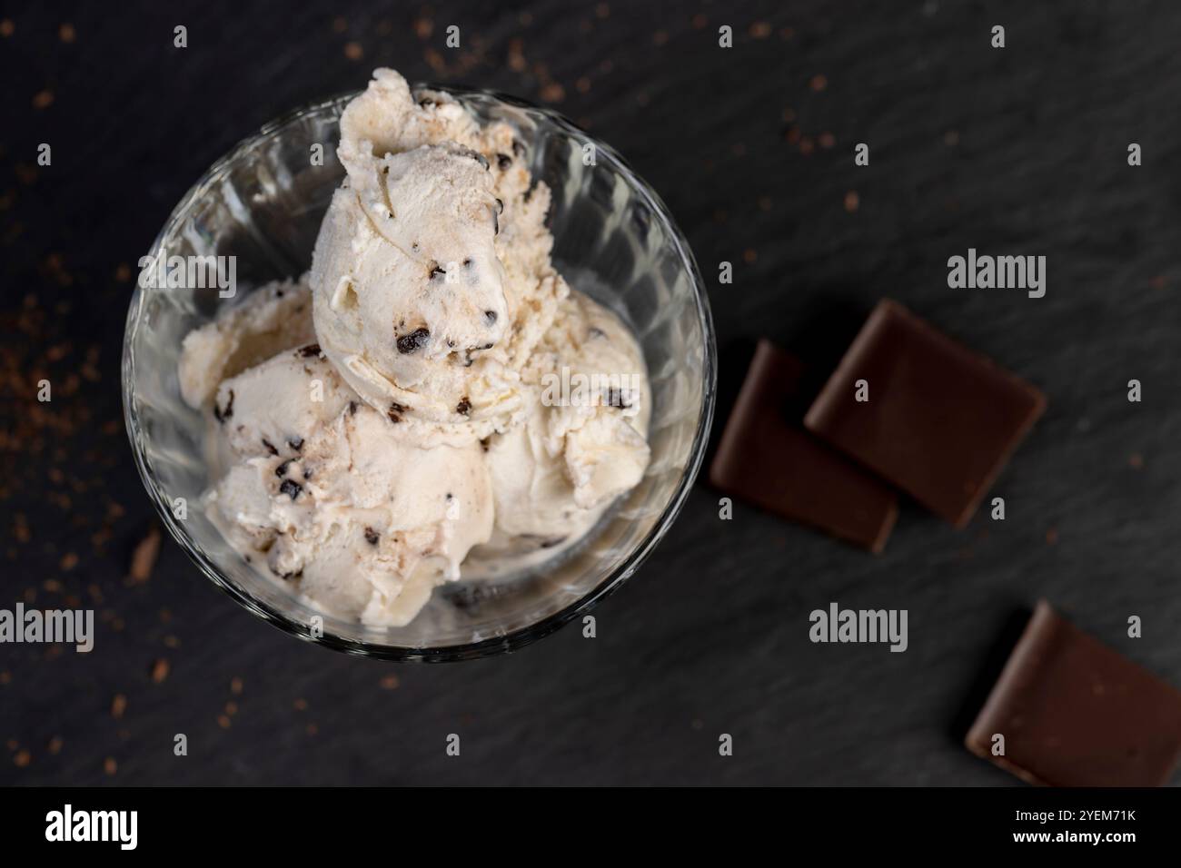 creamy ice cream with pieces and crumbs of chocolate in a glass bowl ...