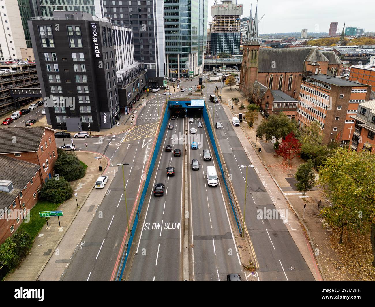 Aerial view of cars driving on a city street and entering an underpass ...