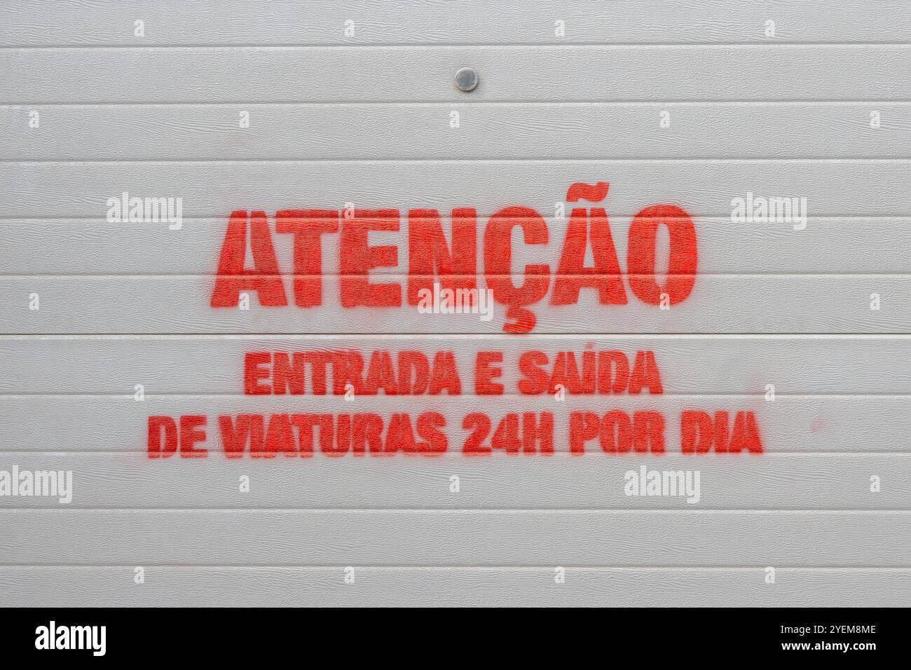 Red stencil sign on a white corrugated metal surface indicating vehicle ...