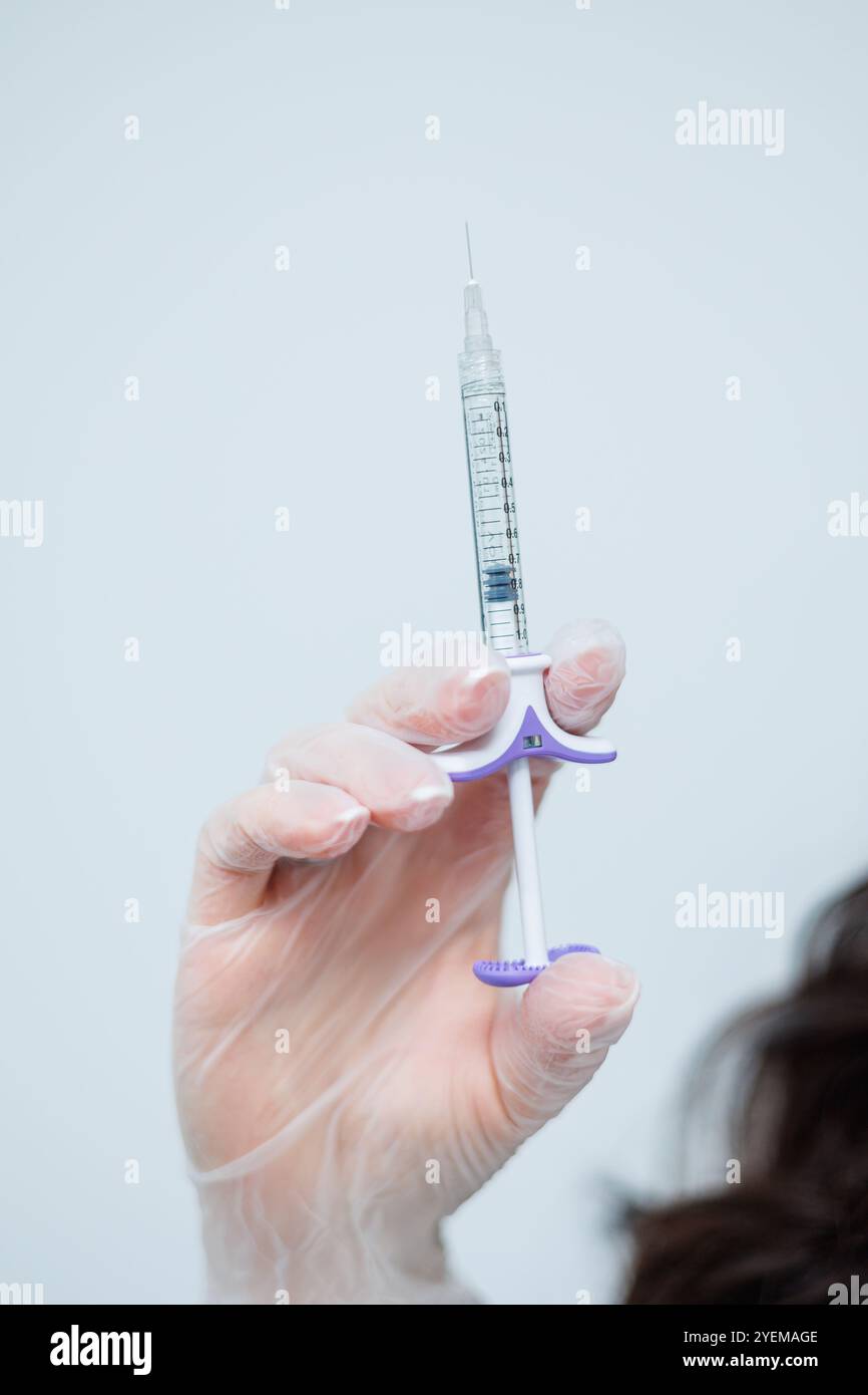 Female hand in gloves with syringe in hand. Syringe for injections in ...