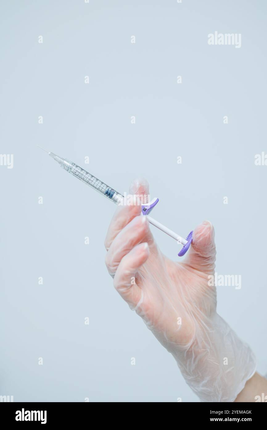 Female hand in gloves with syringe in hand. Syringe for injections in ...