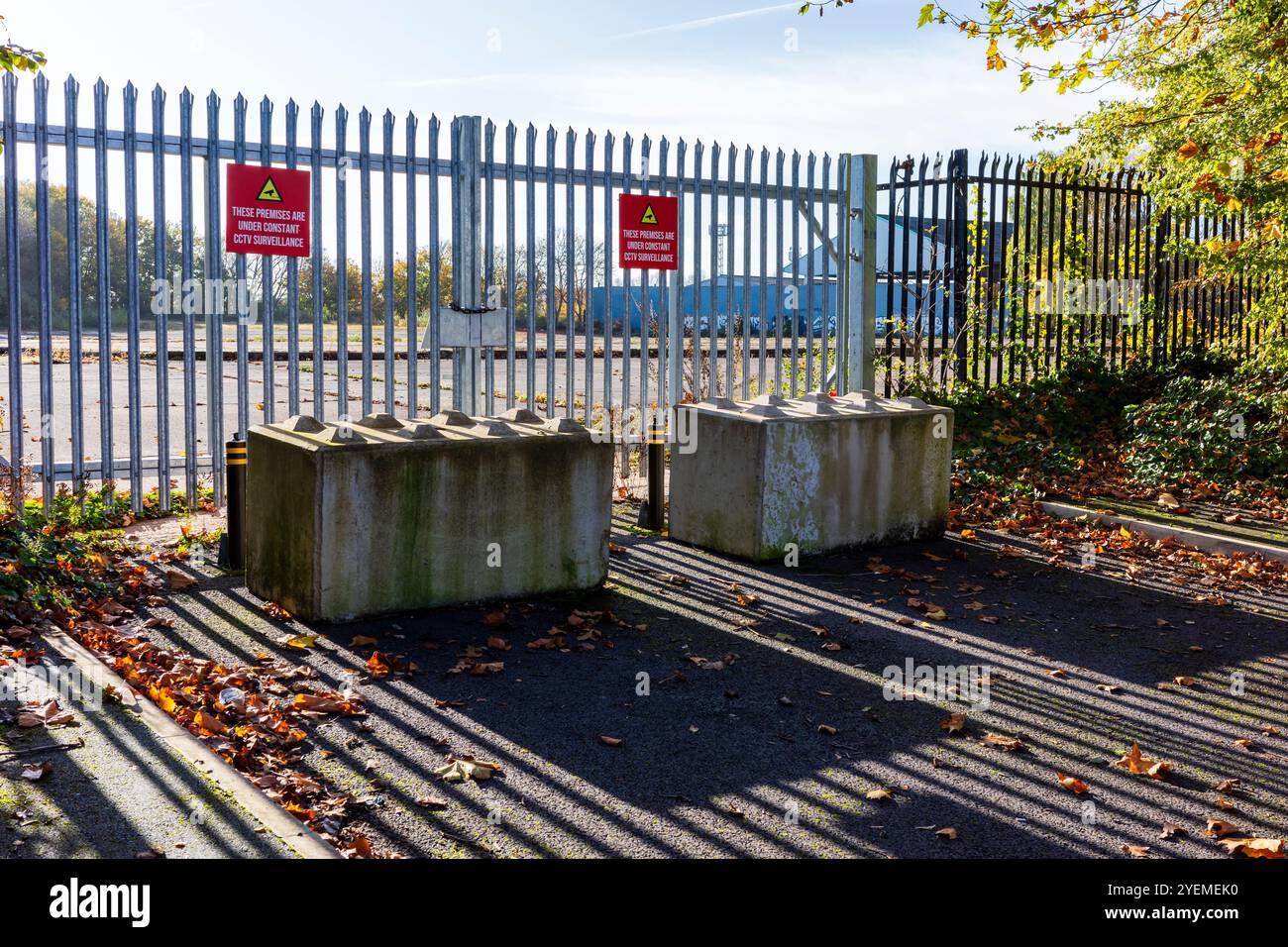 Sunlit industrial gate blocked with concrete blocks Stock Photo - Alamy