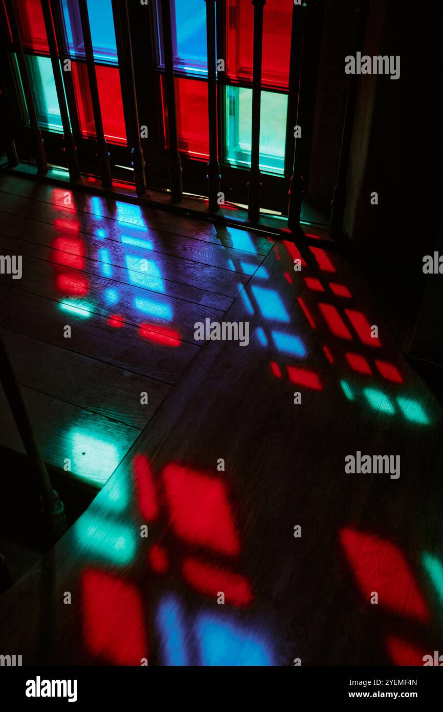 Vertical high angle shot of stained glass reflections on wooden floor ...