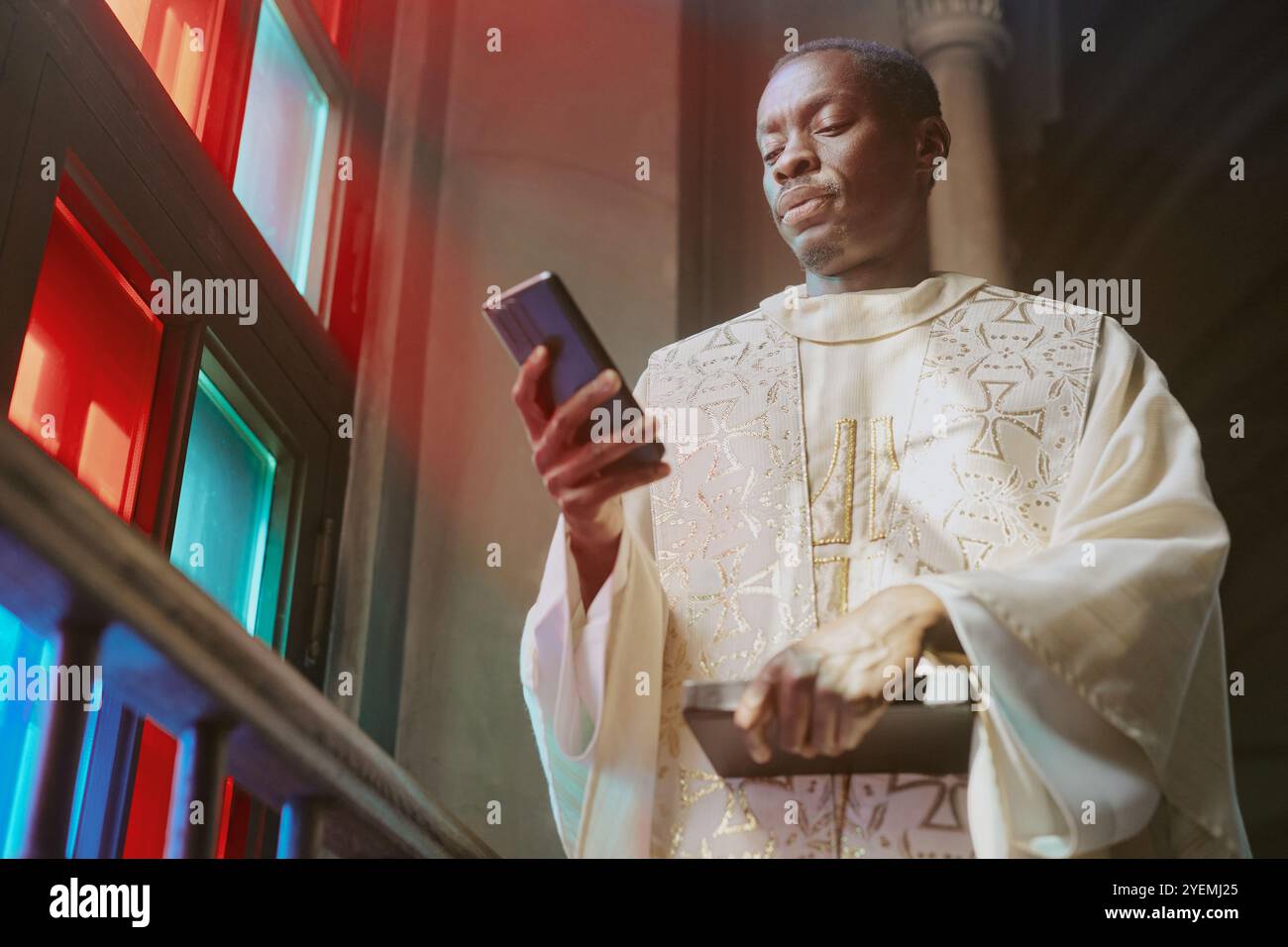 Low angle shot of African American priest in beautiful robe checking ...