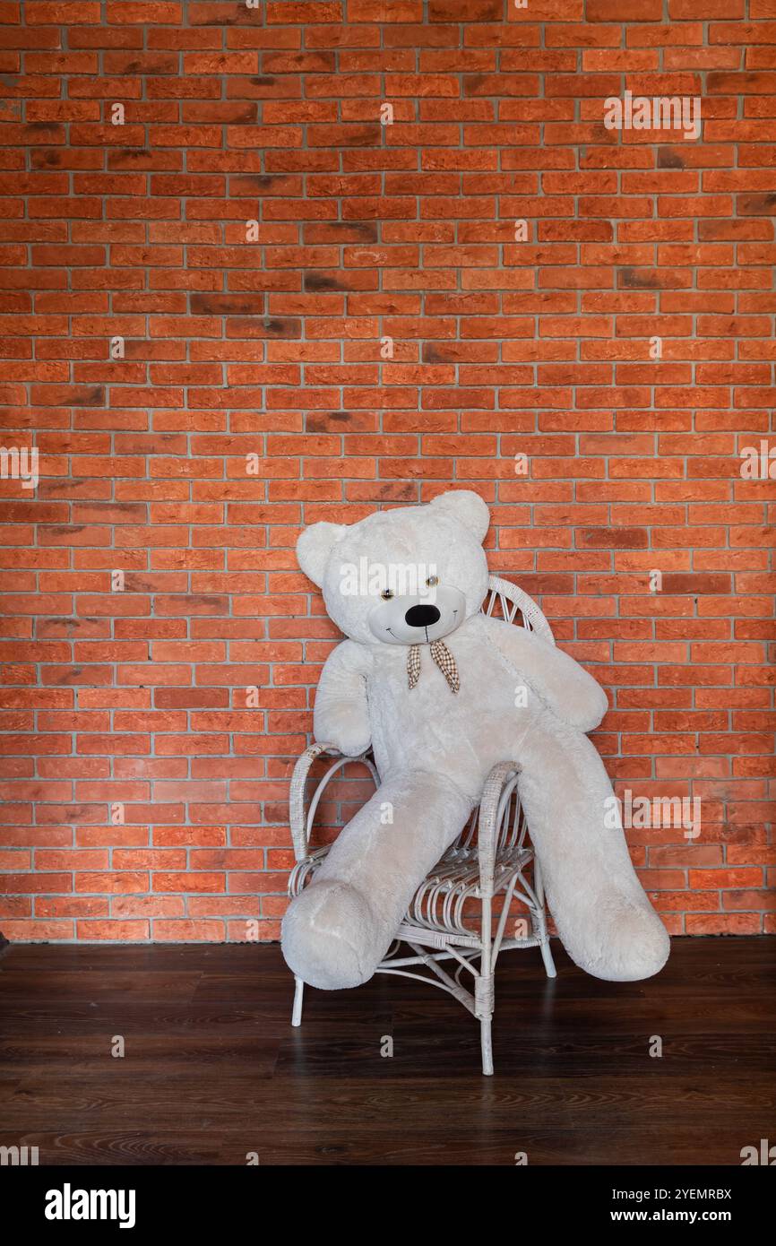 Toy Teddy Bear in an Armchair by a Brick Wall Stock Photo - Alamy