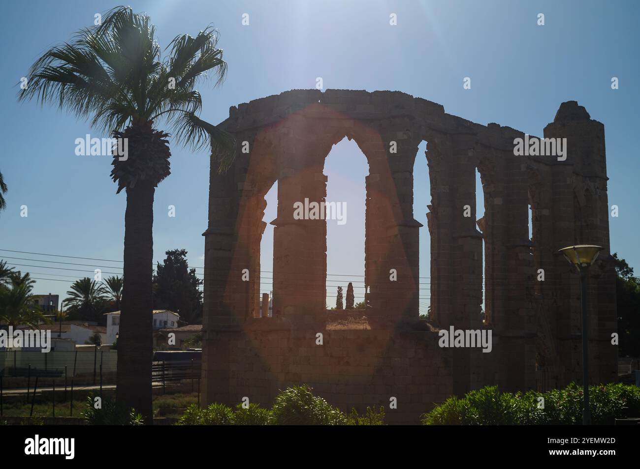 Visitors admire the stunning ruins under a bright sky, capturing the ...