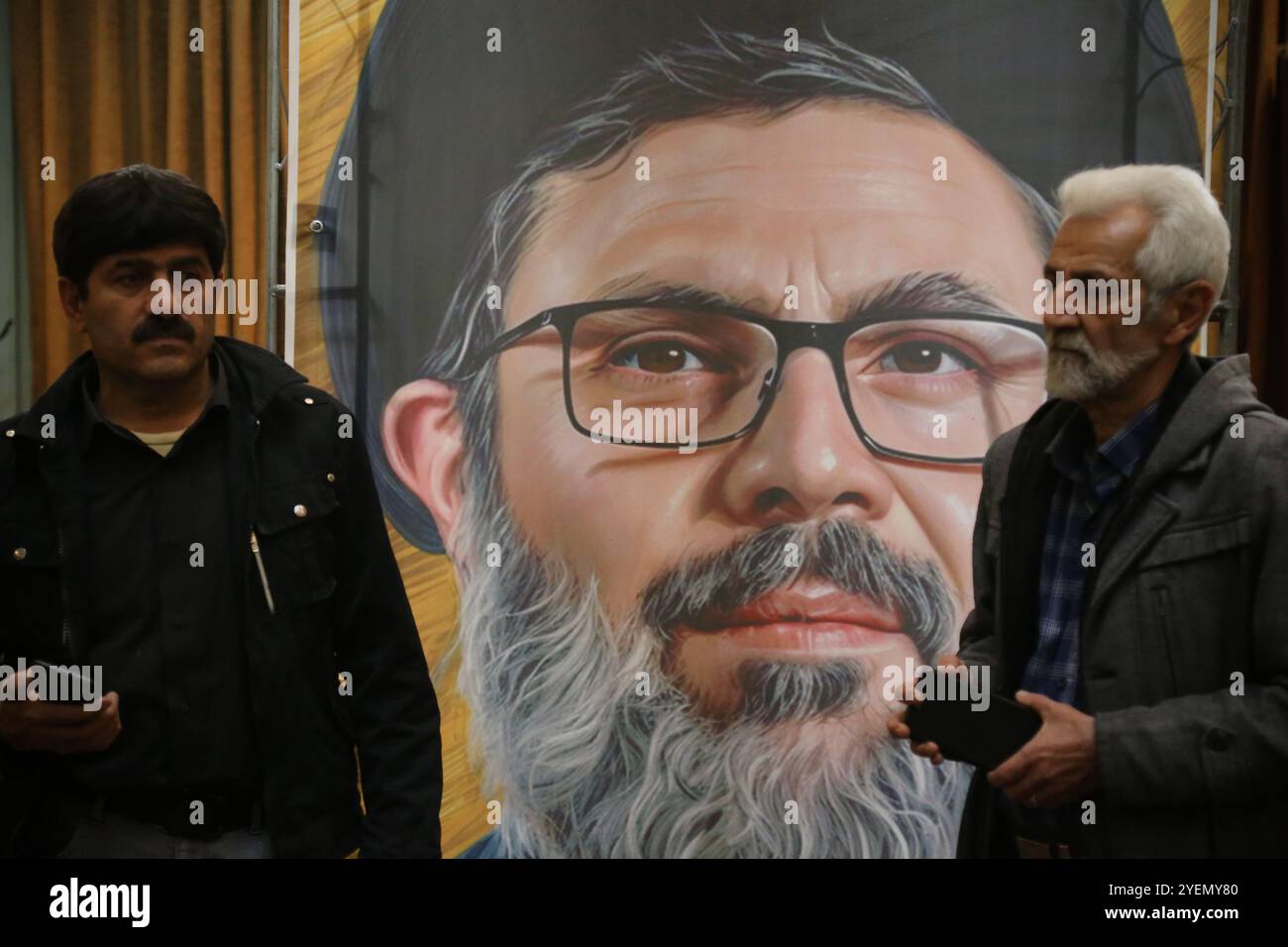 Tehran, Iran. 31st Oct, 2024. Two Iranian men stand to a huge portrait ...