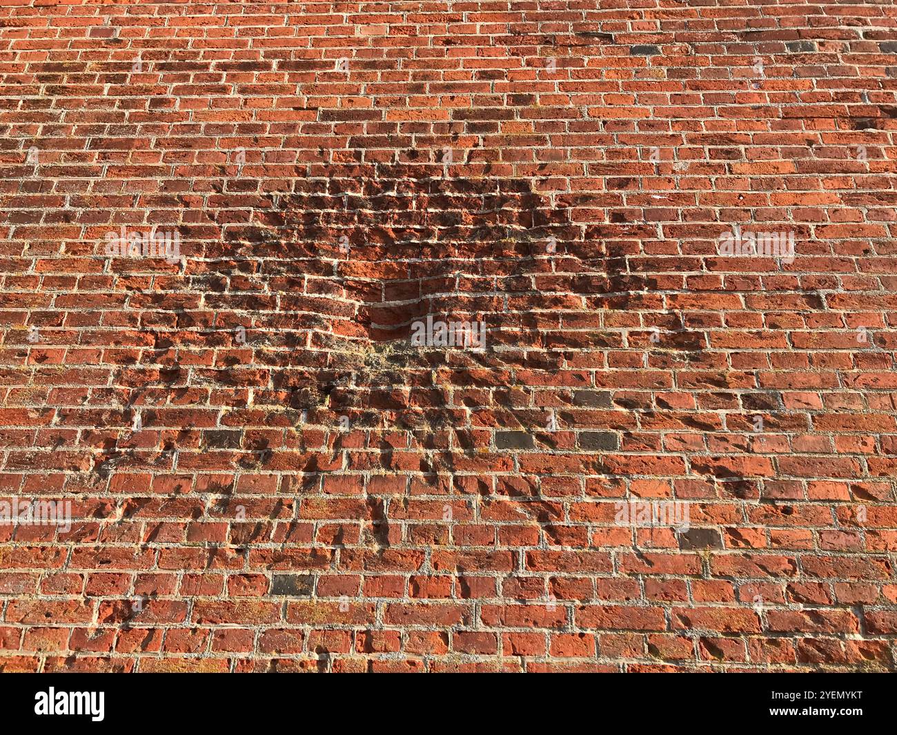 Traces of war - shrapnel, bullets marks on the red bricks wall. Old ...