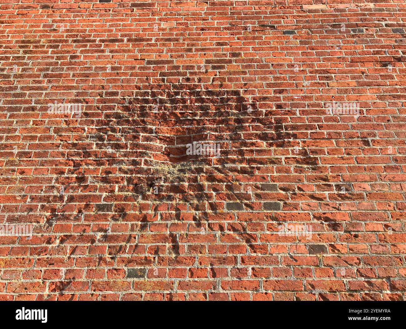 Traces of war - shrapnel, bullets marks on the red bricks wall. Old ...