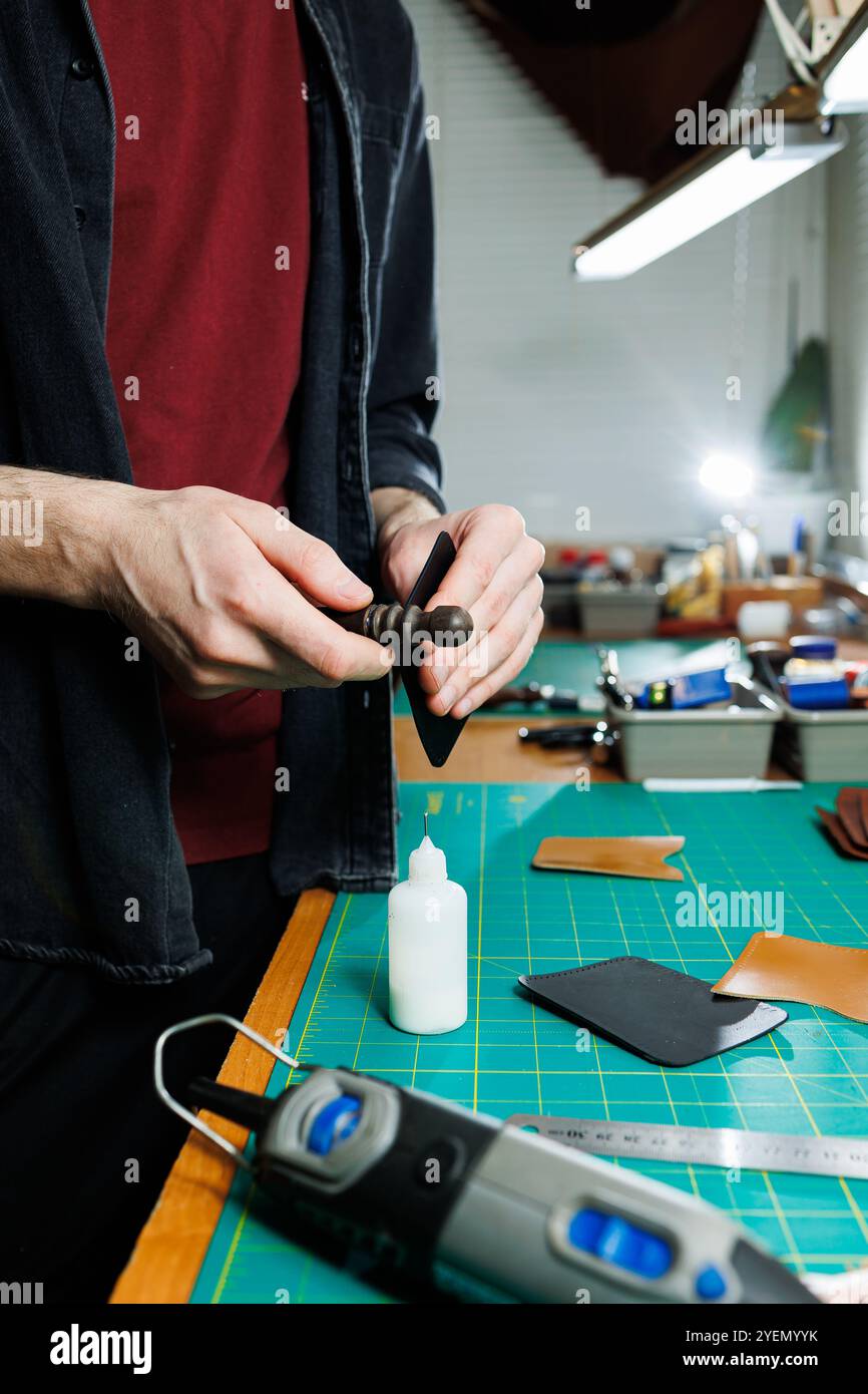 The hands of the master sew handmade leather products. Men's hands ...
